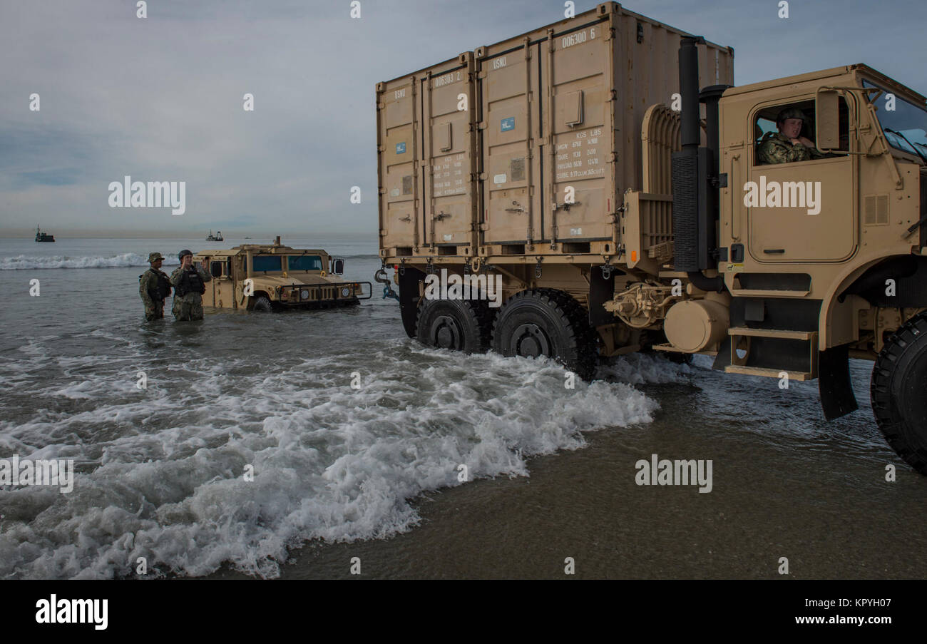 Sailors assigned to Beachmaster Unit One (BMU-1) guide a Medium Tactical Vehicle Replacement ...