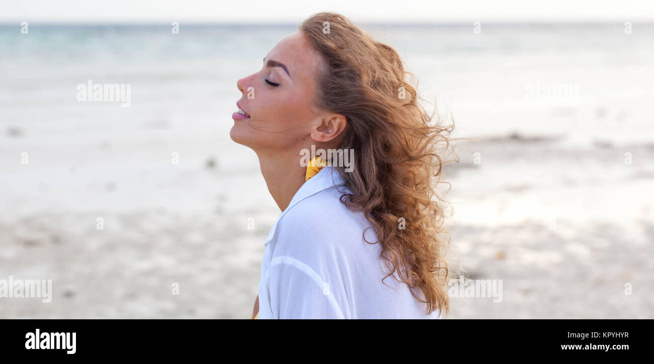 Attractive woman enjoy sea scent smelling wind with closed eyes on sea ...