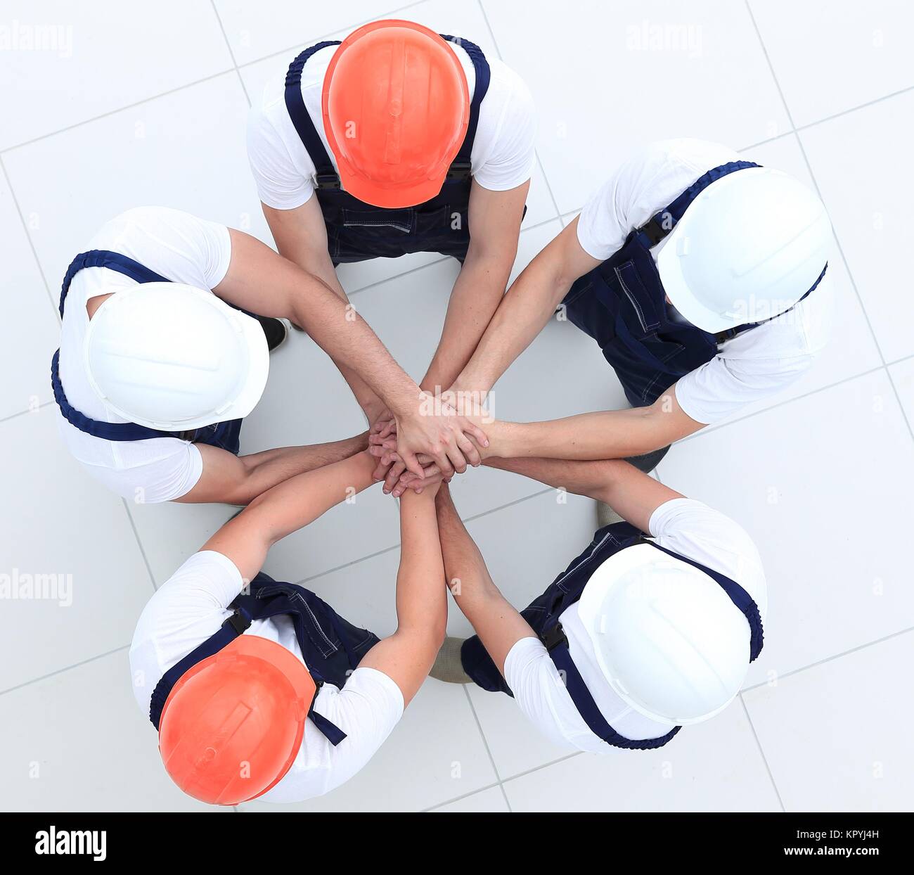 group of construction workers with hands clasped together Stock Photo ...
