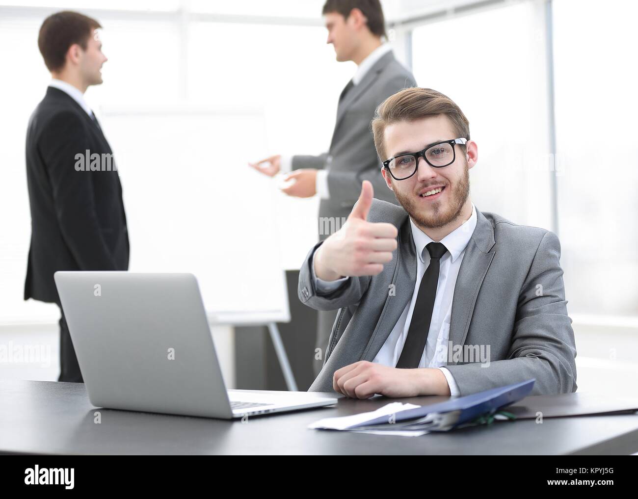 Manager sitting at his Desk and showing thumbs up Stock Photo - Alamy