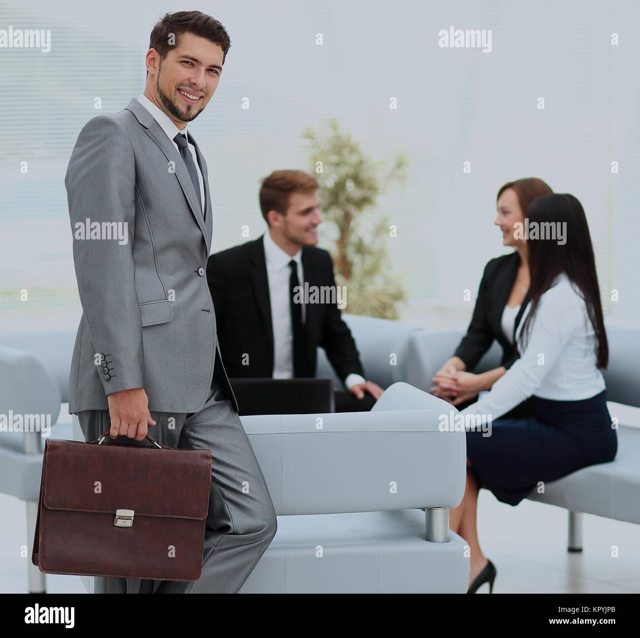 Successful business man standing with his staff in background at Stock ...