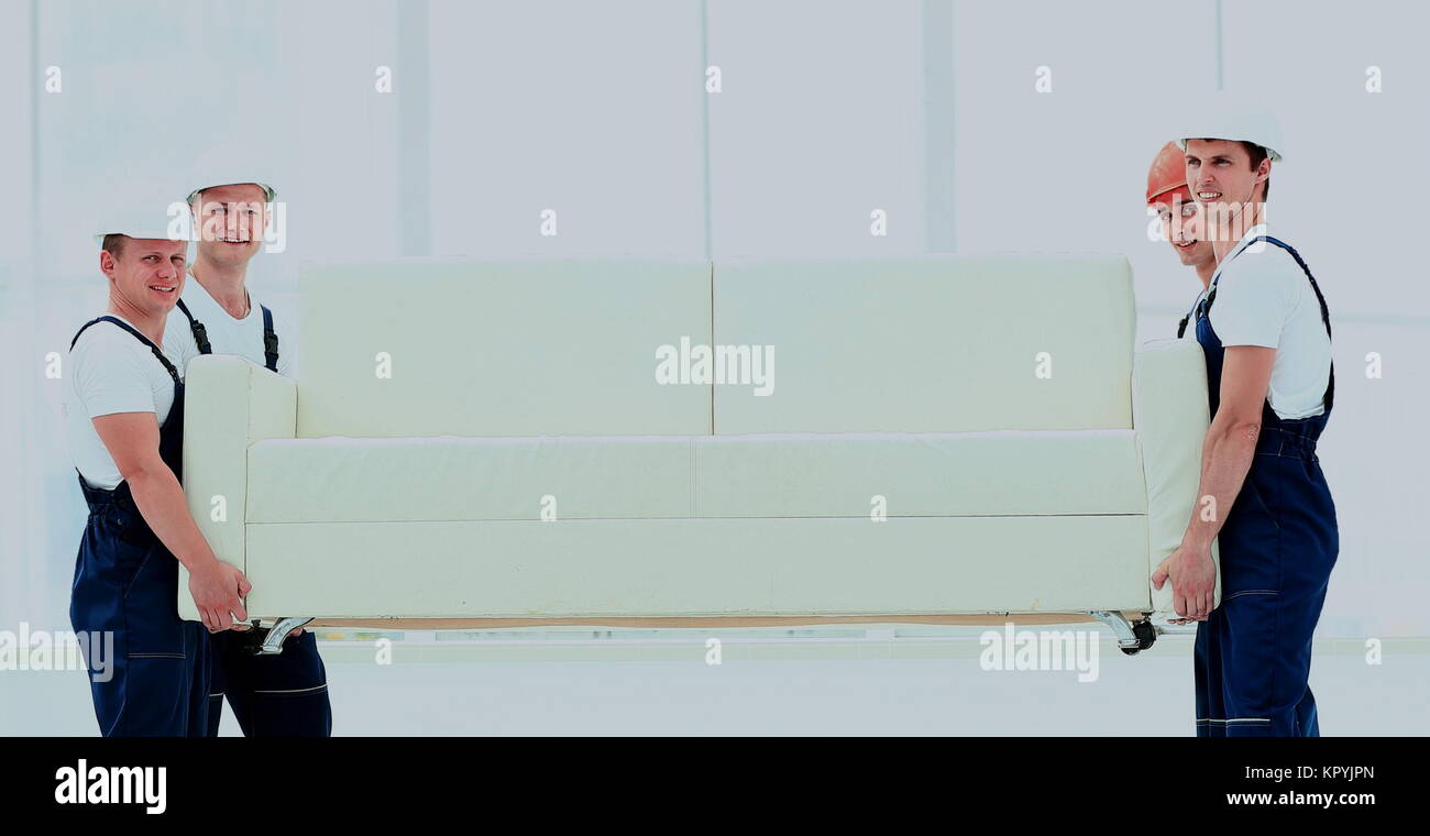 happy male movers in uniform carrying white sofa Stock Photo - Alamy