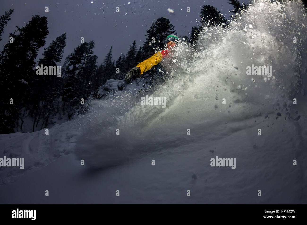 freerider snowboarder jumping at night with a springboard in the forest ...