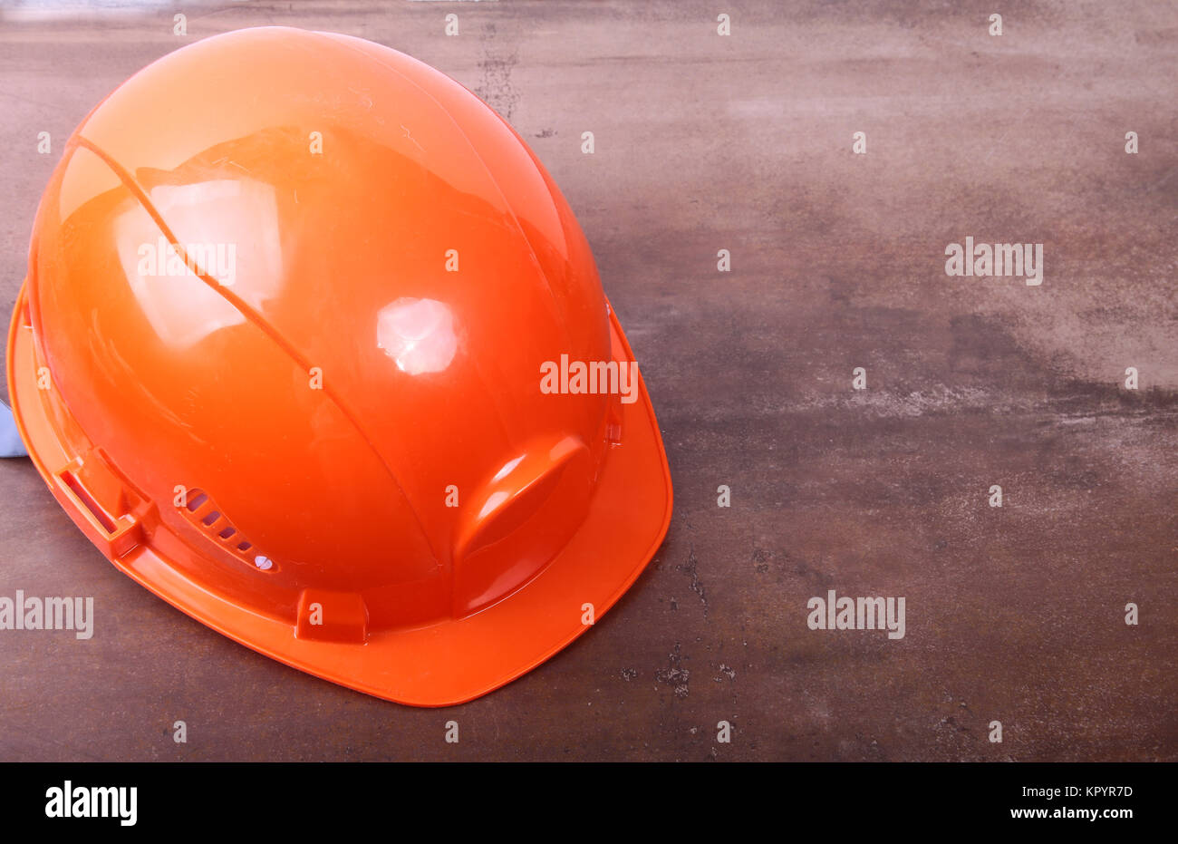 Orange safety engineer helmet on brown background Stock Photo - Alamy