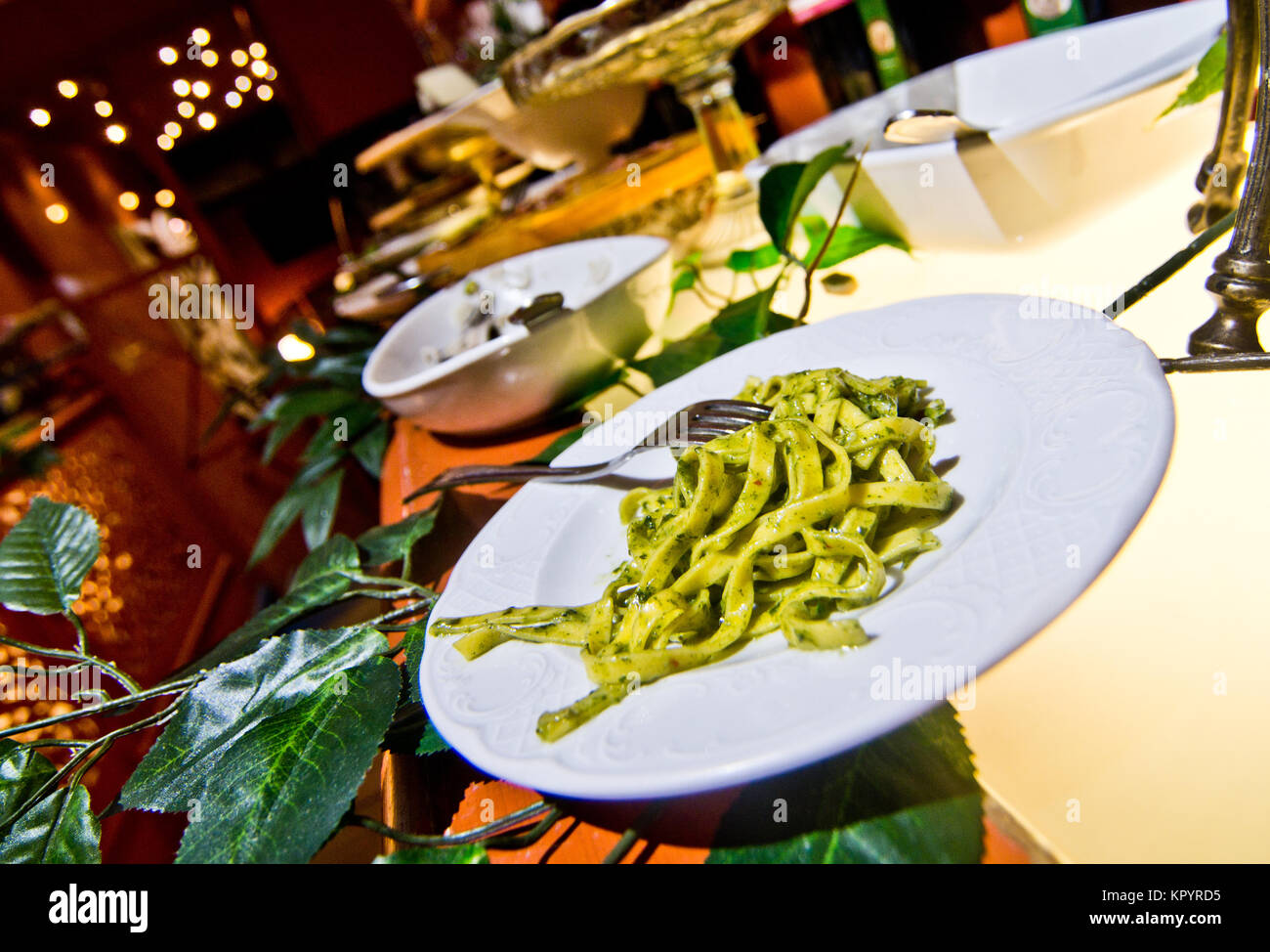 pasta dish topped with pesto sauce on the buffet counter of a trendy ...