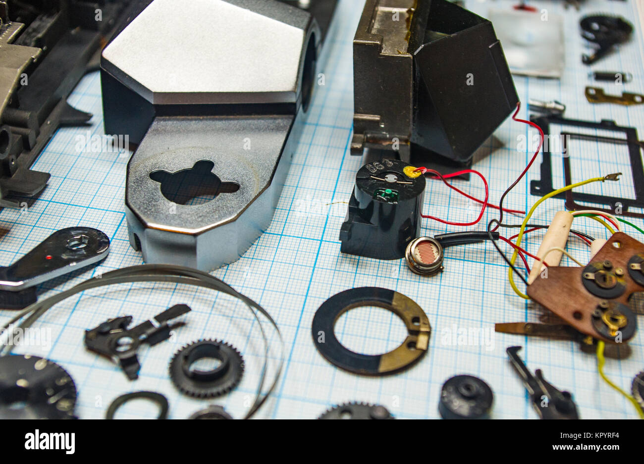 parts are completely disassembled old retro film SLR camera on graph ...