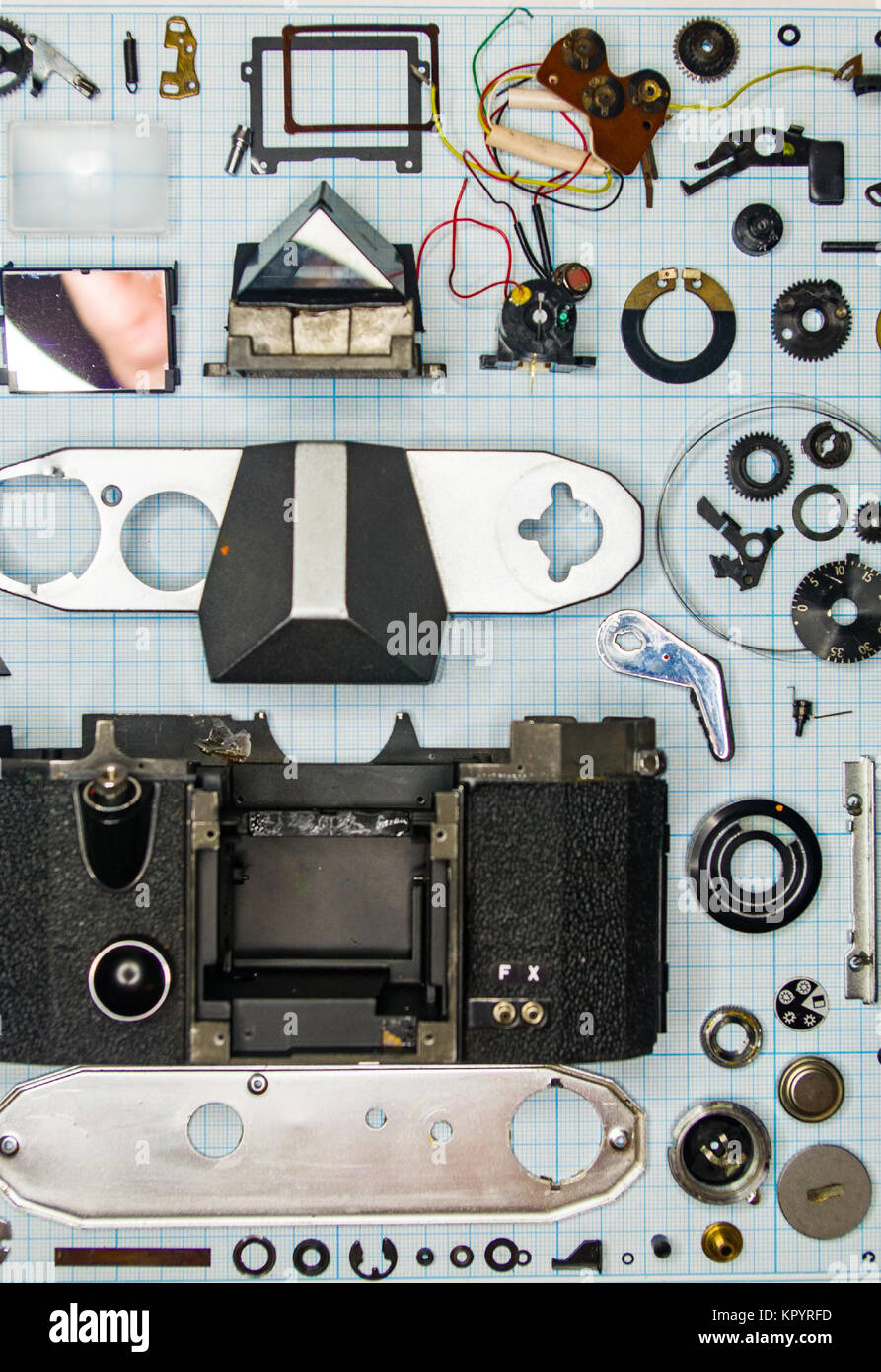 parts are completely disassembled old retro film SLR camera on graph ...