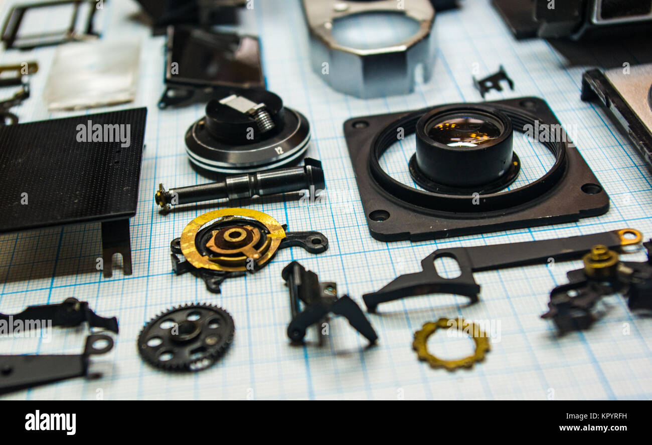parts are completely disassembled old retro film SLR camera on graph ...