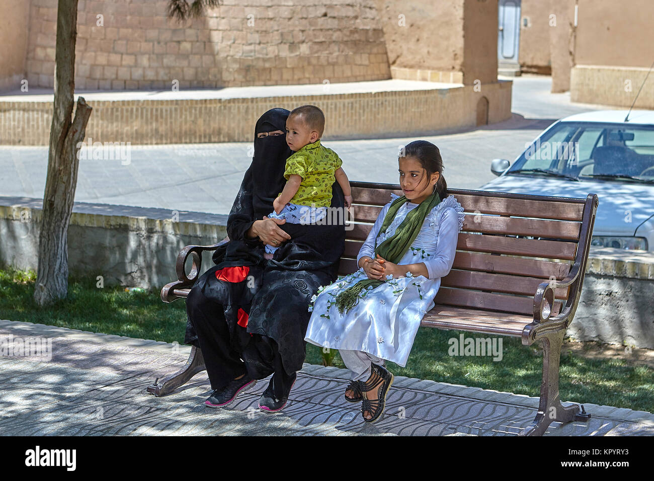 Yazd, Iran - April 21, 2017: An Arab family of three people sitting on ...
