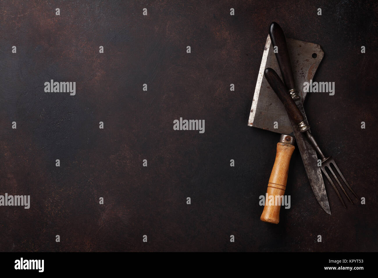 Vintage meat kitchen utensils over stone table. Top view with space for ...