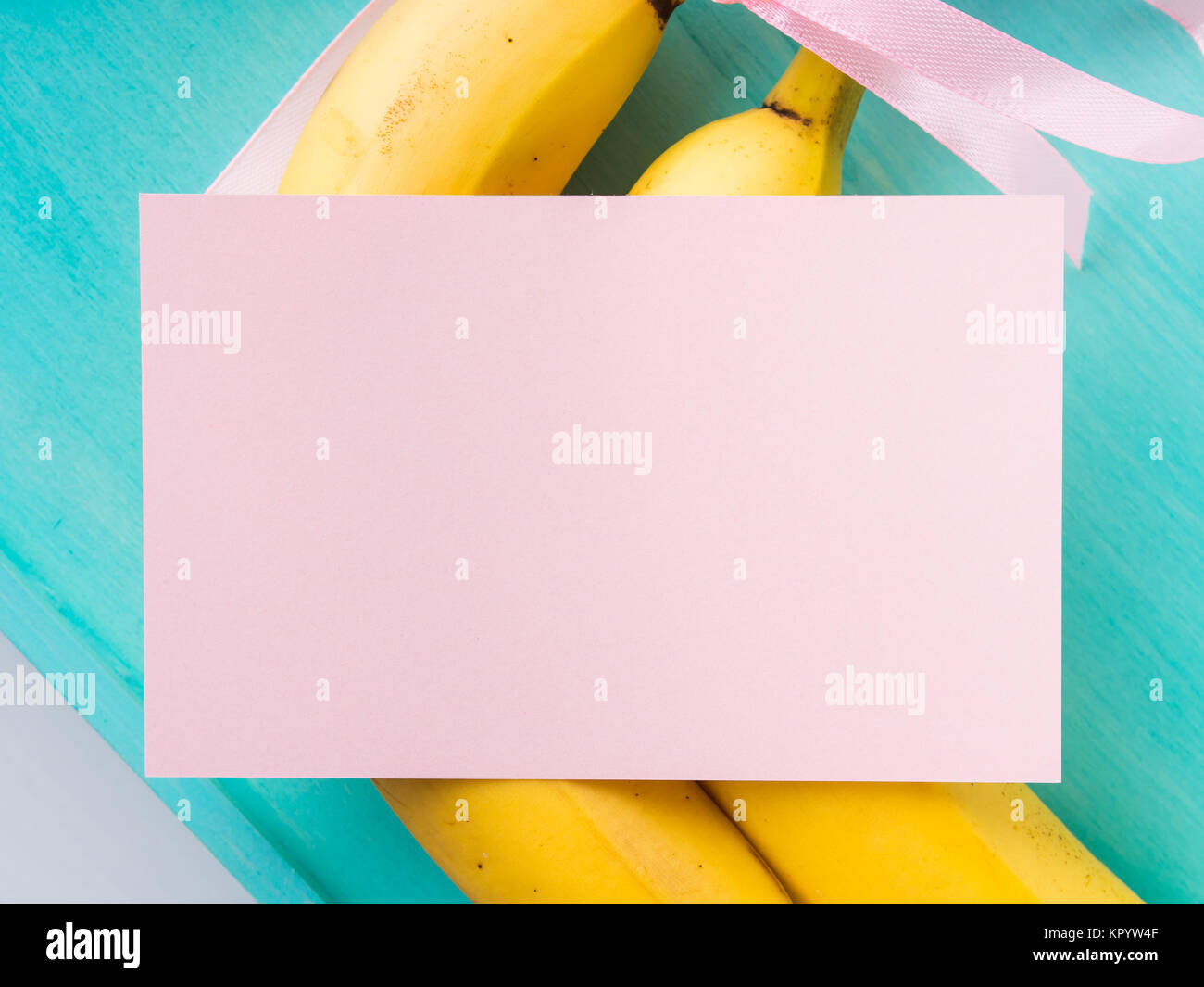Two bananas with pink ribbon and card on green pastel background Stock ...