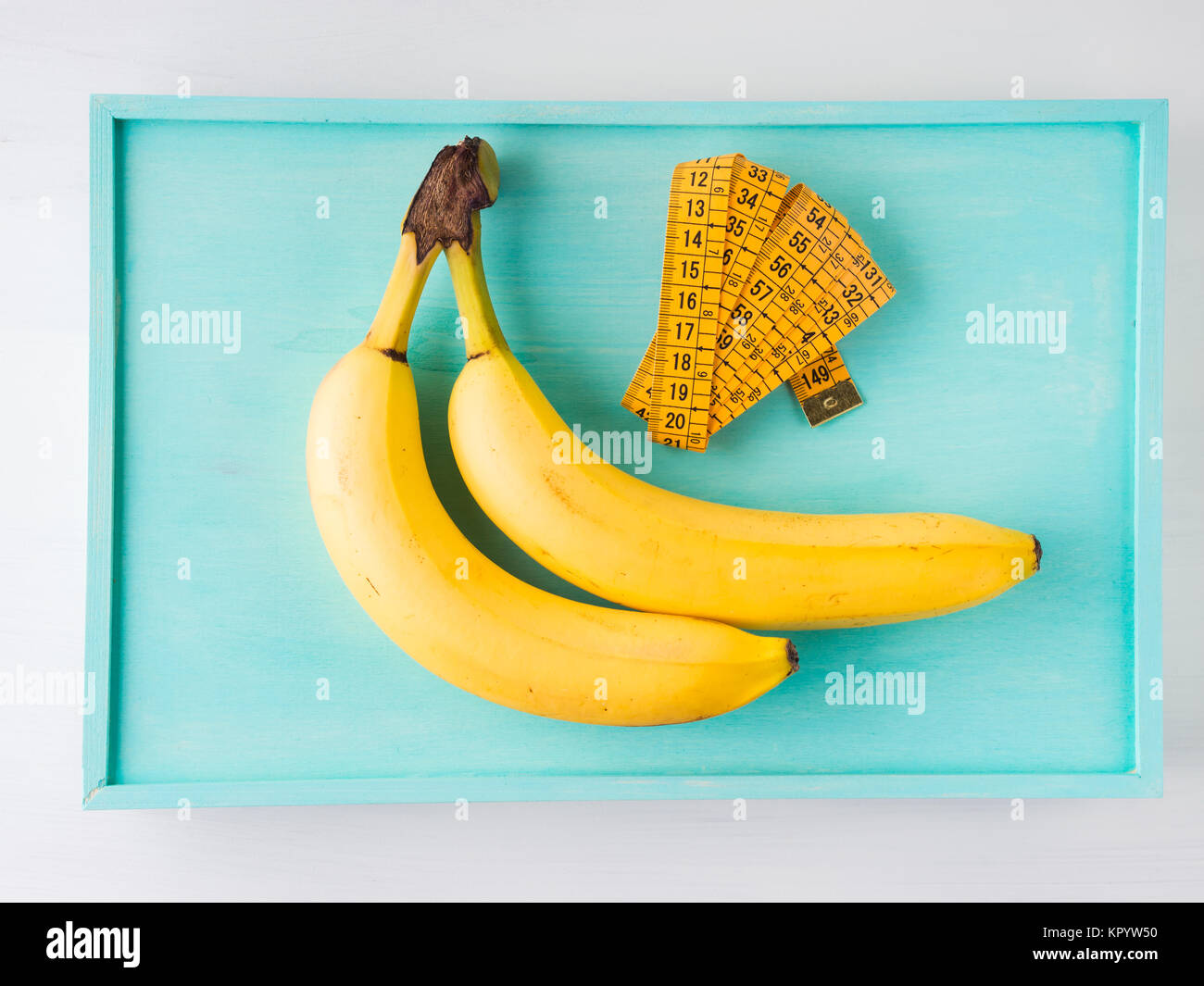 Two bananas with measuring meter on green pastel Stock Photo - Alamy