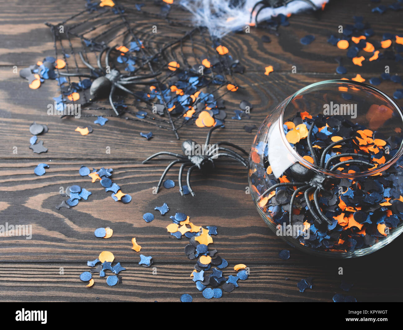 Halloween orange and black confetti with spiders and spider net on dark ...