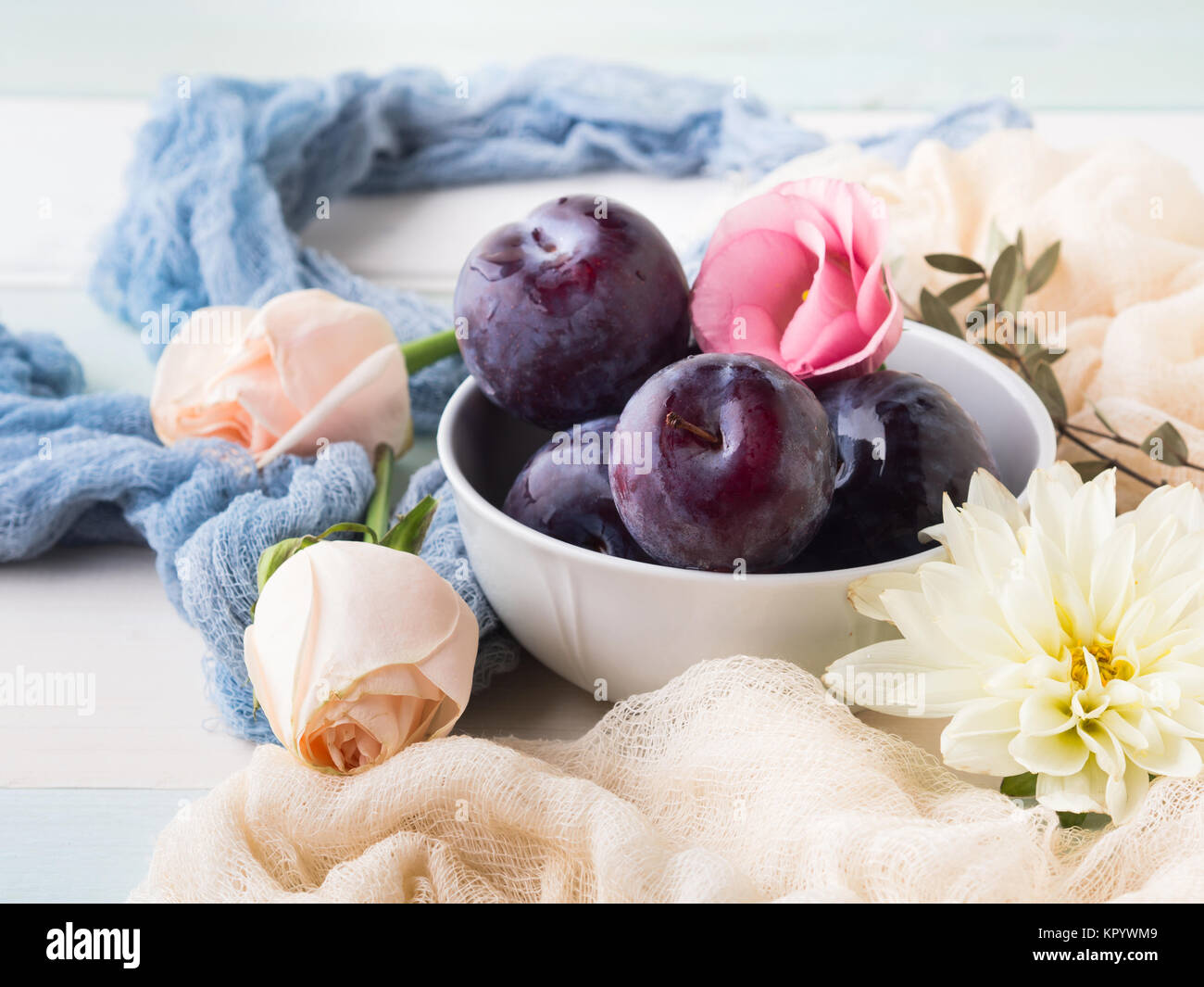 Blue plums in bowl with pink flowers. Summer autumn fruit Stock Photo ...