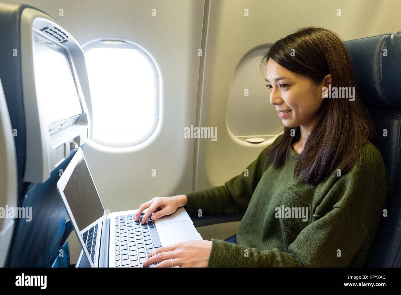 Woman working with laptop computer at airplane Stock Photo - Alamy