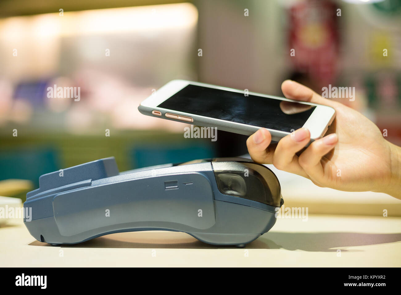 Customer using mobile phone to pay by NFC Stock Photo - Alamy