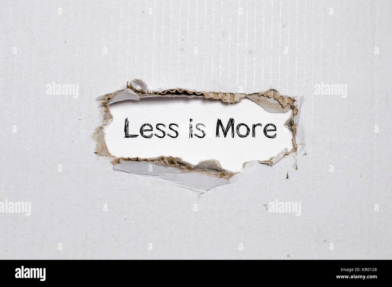The word less is more appearing behind torn paper Stock Photo - Alamy