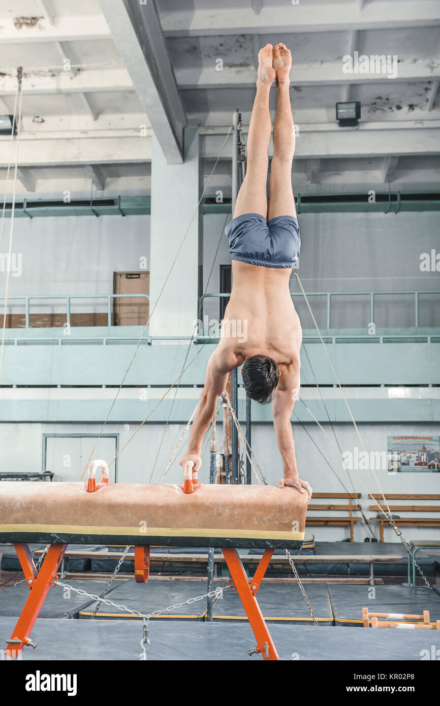 The sportsman during difficult exercise, sports gymnastics Stock Photo ...