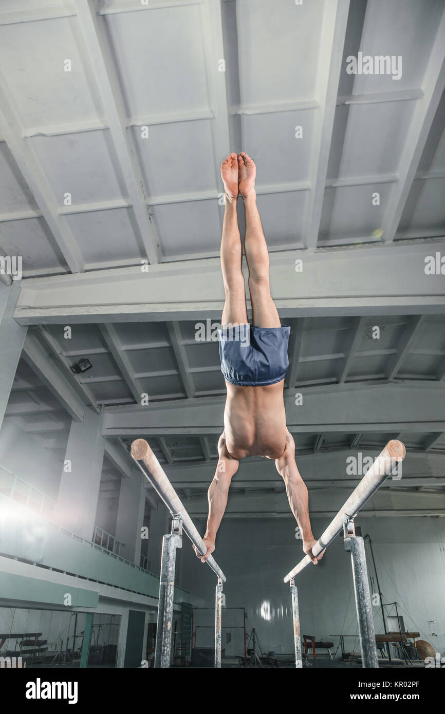 Male gymnast performing handstand on parallel bars Stock Photo - Alamy