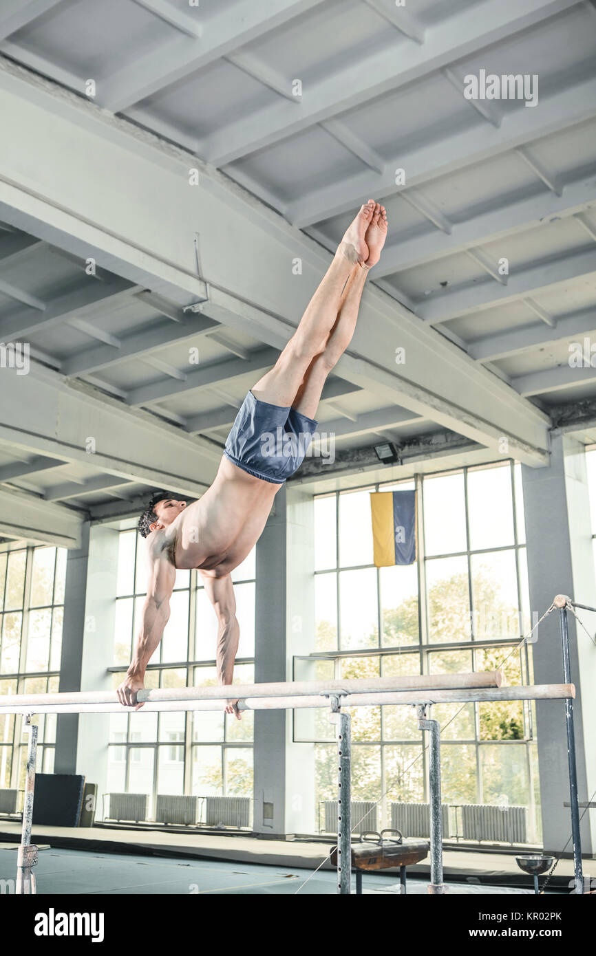 Male gymnast performing handstand on parallel bars Stock Photo - Alamy