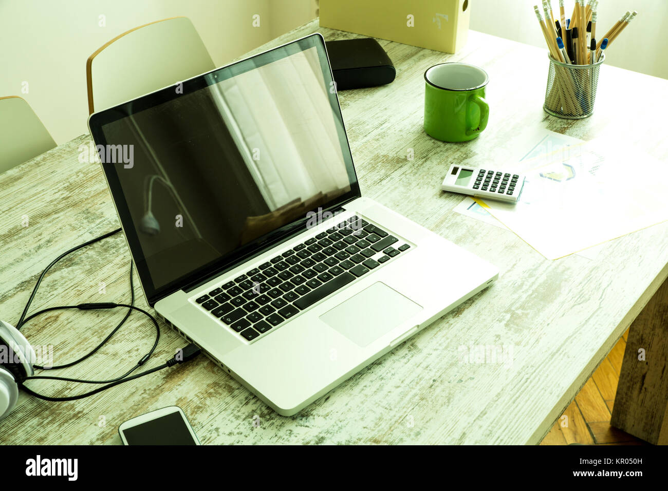 A Laptop in a modern home office setup on a wooden Table Stock Photo ...