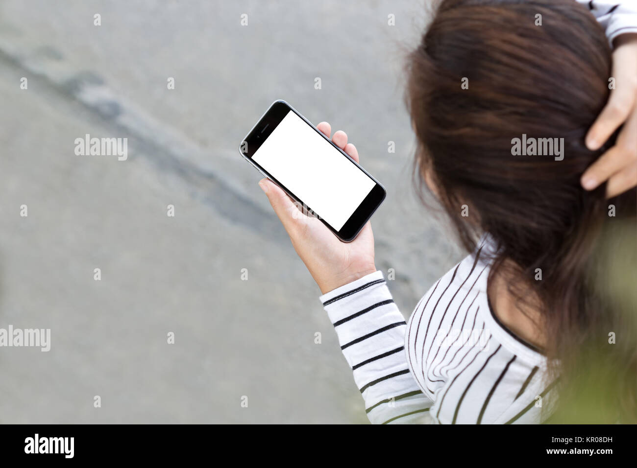 woman looking on phone and walking on road, third-person view Stock ...