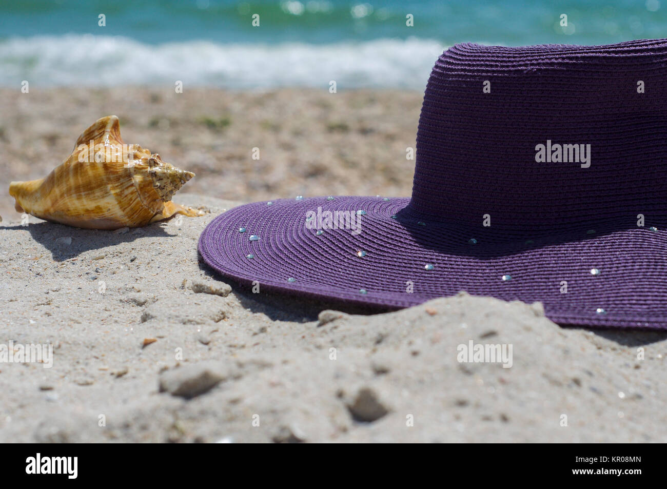 Hat and seashell on the beach Stock Photo - Alamy