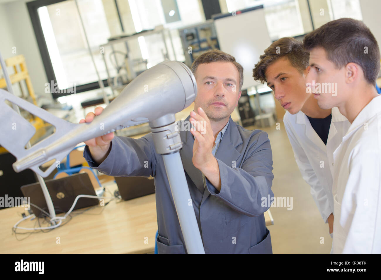Teacher and students looking at an airplane shaped model Stock Photo ...