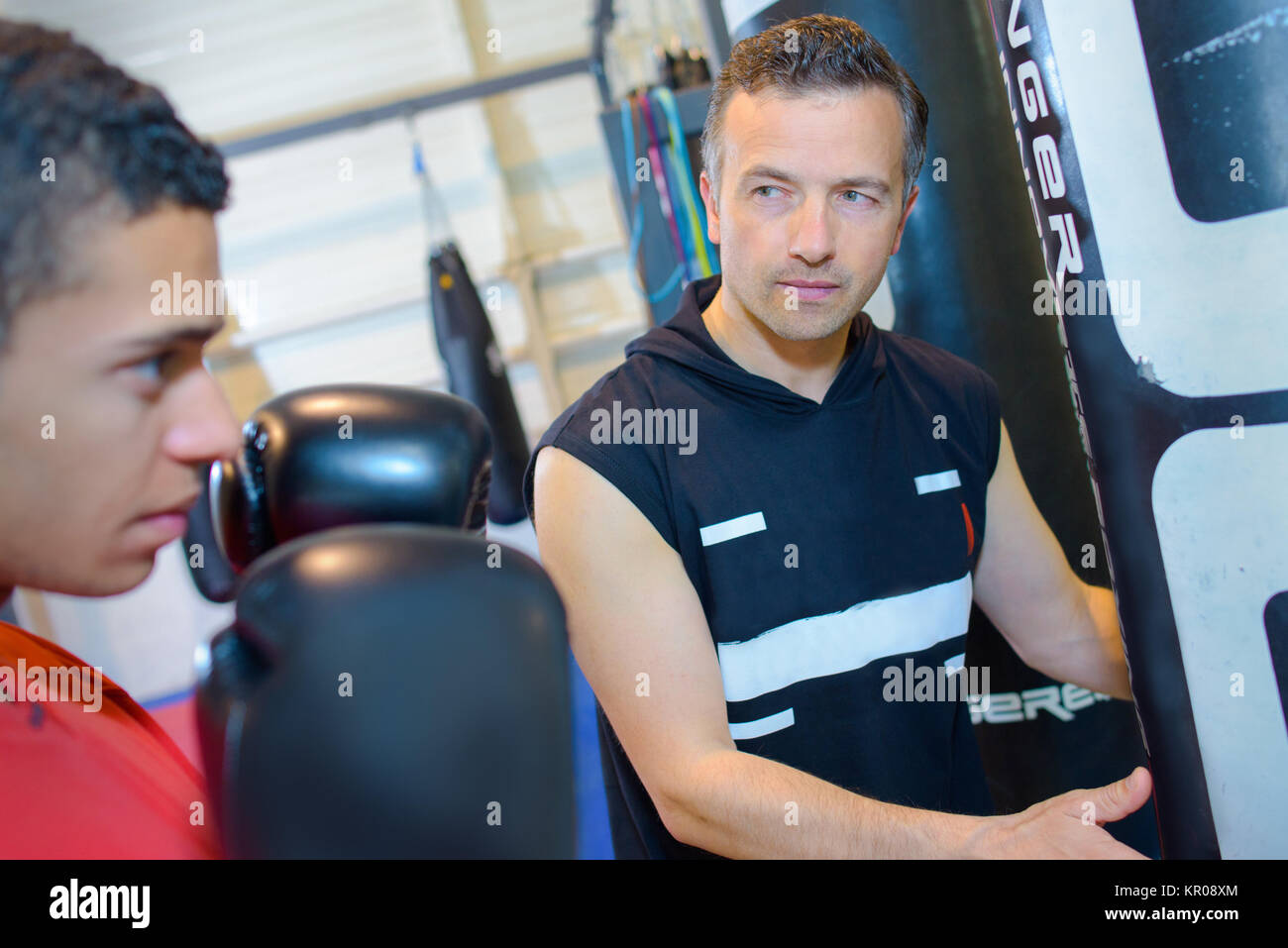 young boxer with coach and punching bag Stock Photo - Alamy