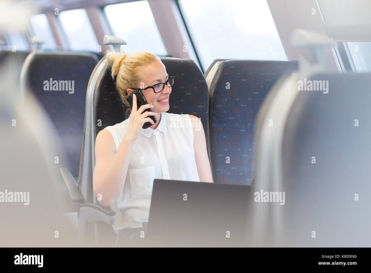 Business woman working while travelling by train Stock Photo - Alamy