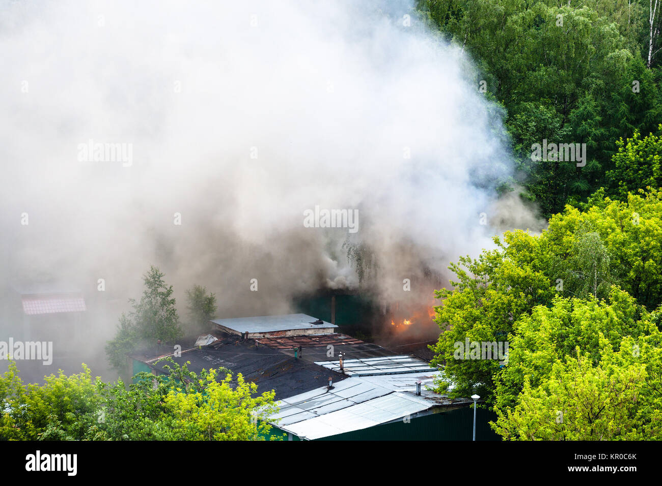 wet roofs, burning garage and white smoke Stock Photo - Alamy