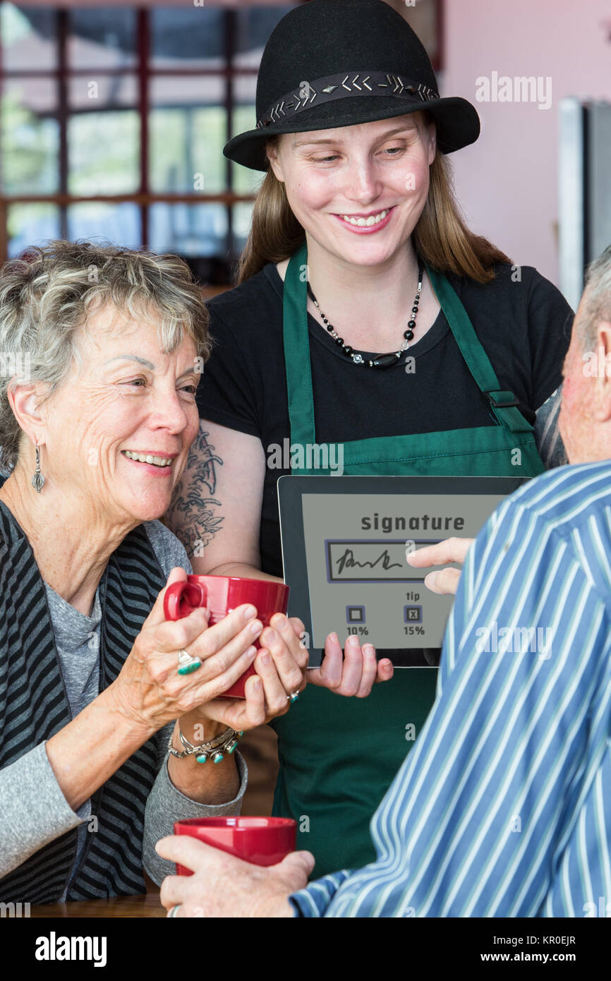 Customer Signs Tablet to Pay in Coffee House Stock Photo - Alamy