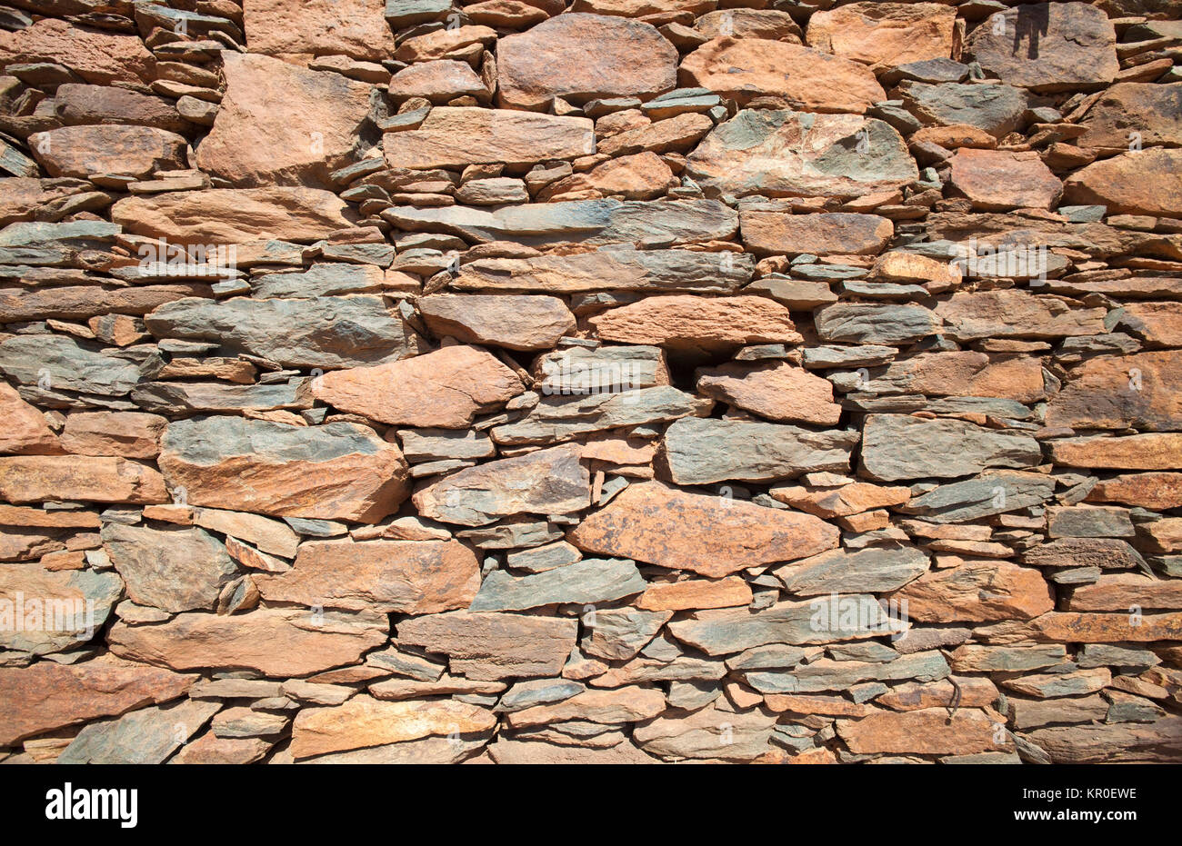outer drystone wall of a house made of flat red rock, locally called ...
