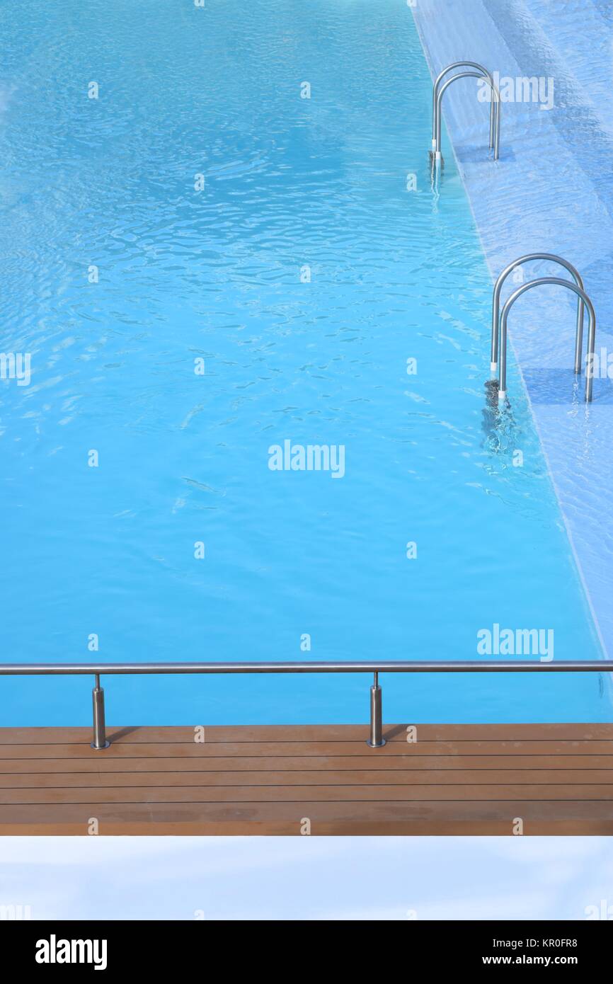 swimming pool with entry on the side and wooden bench by the pool Stock ...