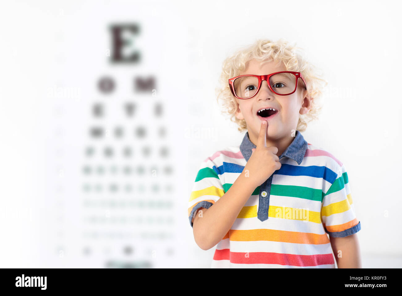 Child at eye sight test. Little kid selecting glasses at optician store ...