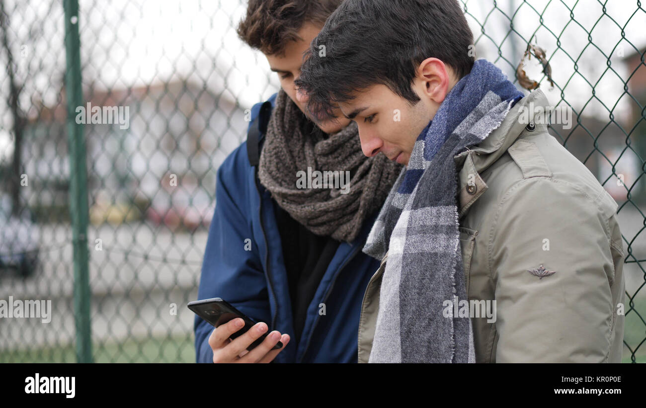 Two young men reading text message or surfing web Stock Photo - Alamy