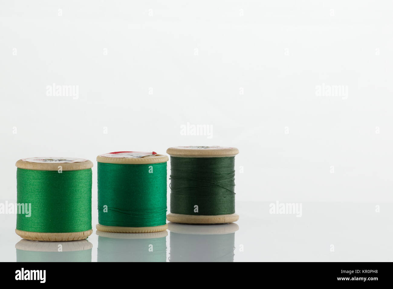 Cotton reels in shades of green isolated on a white background. Sewing ...