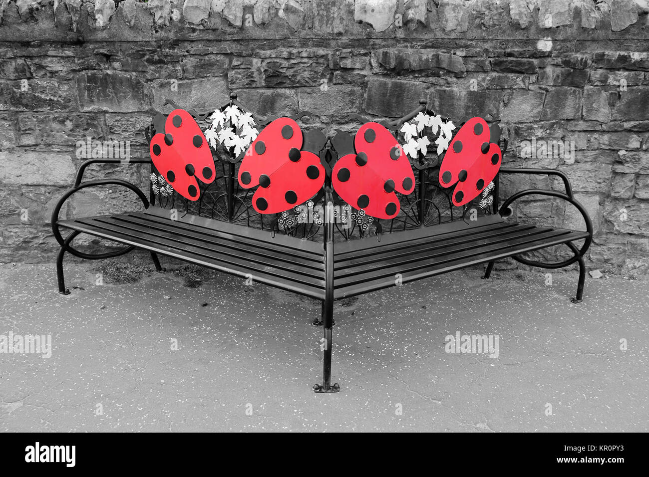 A metal bench with red ladybugs Stock Photo - Alamy