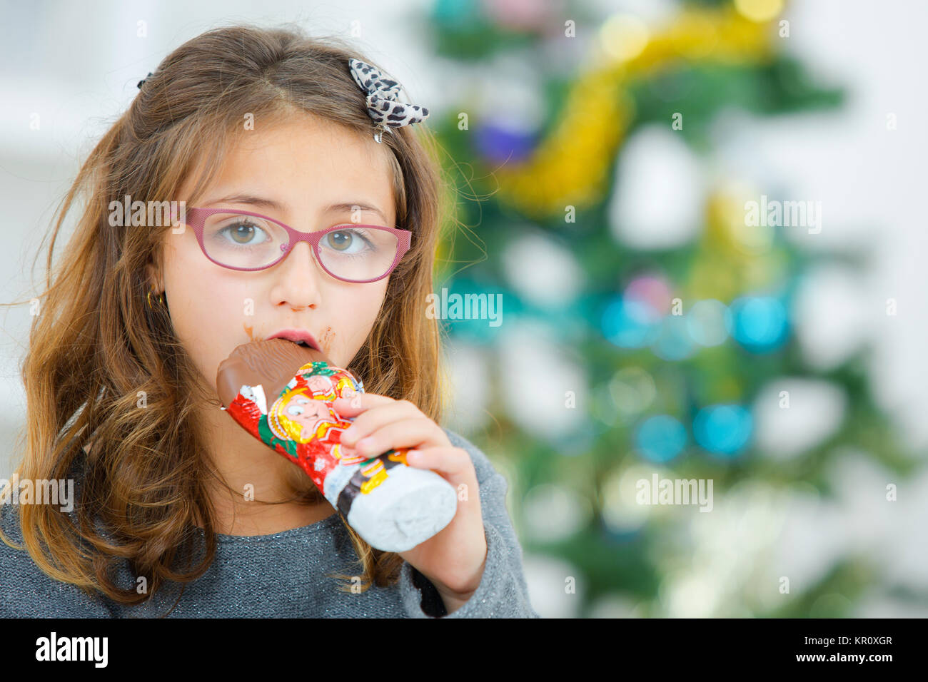 Little girl eating chocolate at Christmas Stock Photo - Alamy