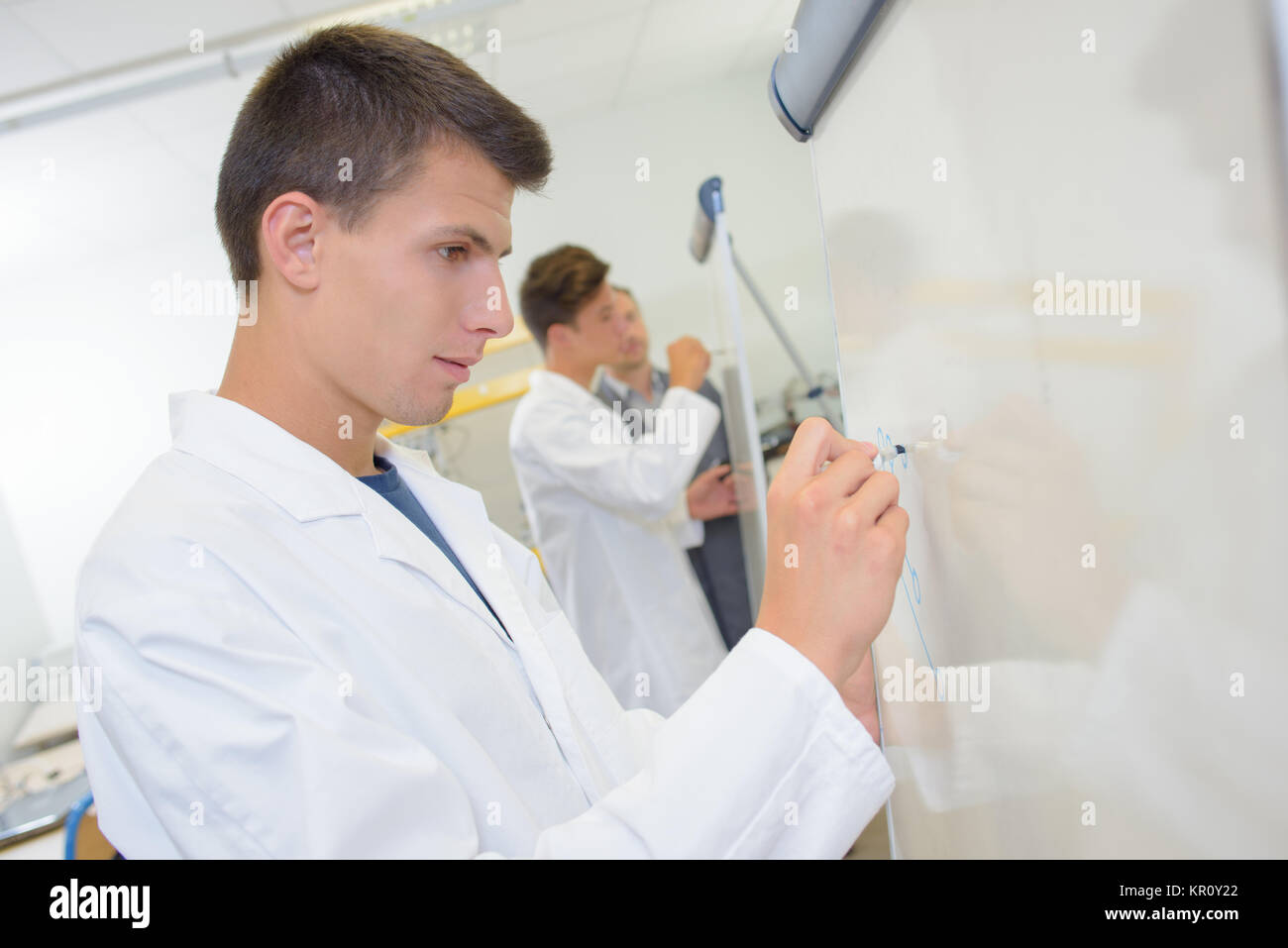 Young man writing on whiteboard Stock Photo - Alamy