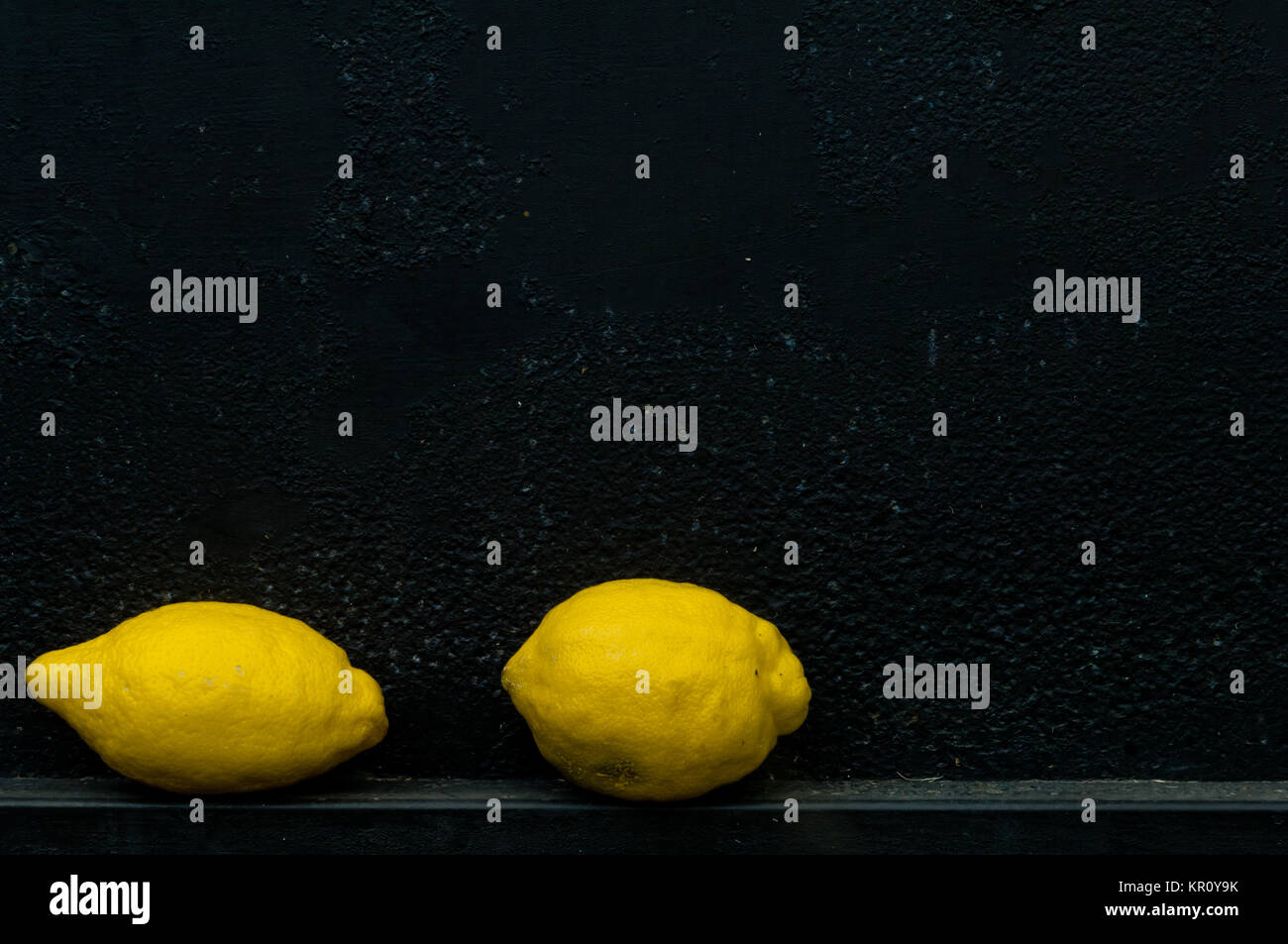 Lemon in front of rough textured black background Stock Photo - Alamy