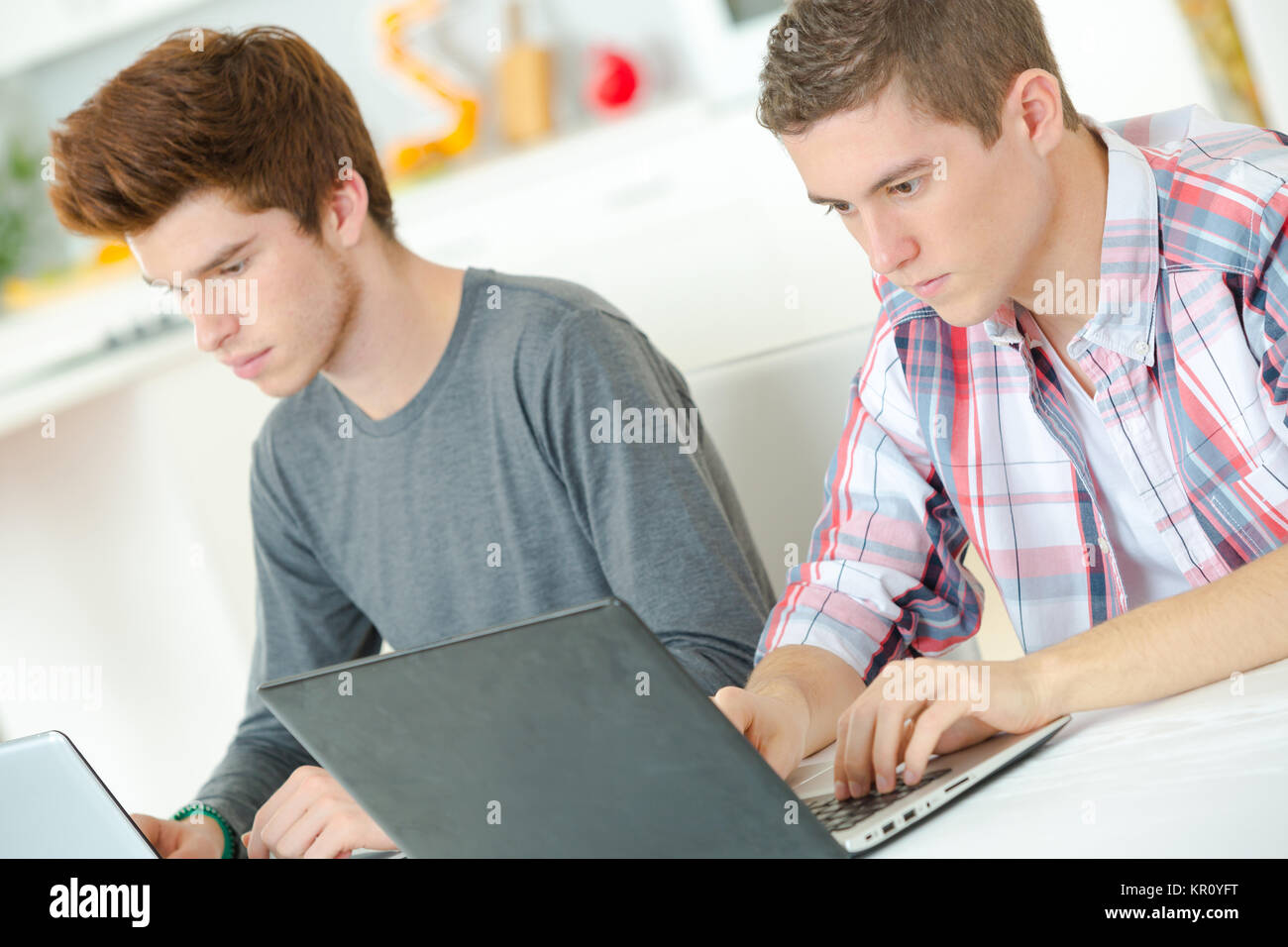 Two male students using laptops Stock Photo - Alamy