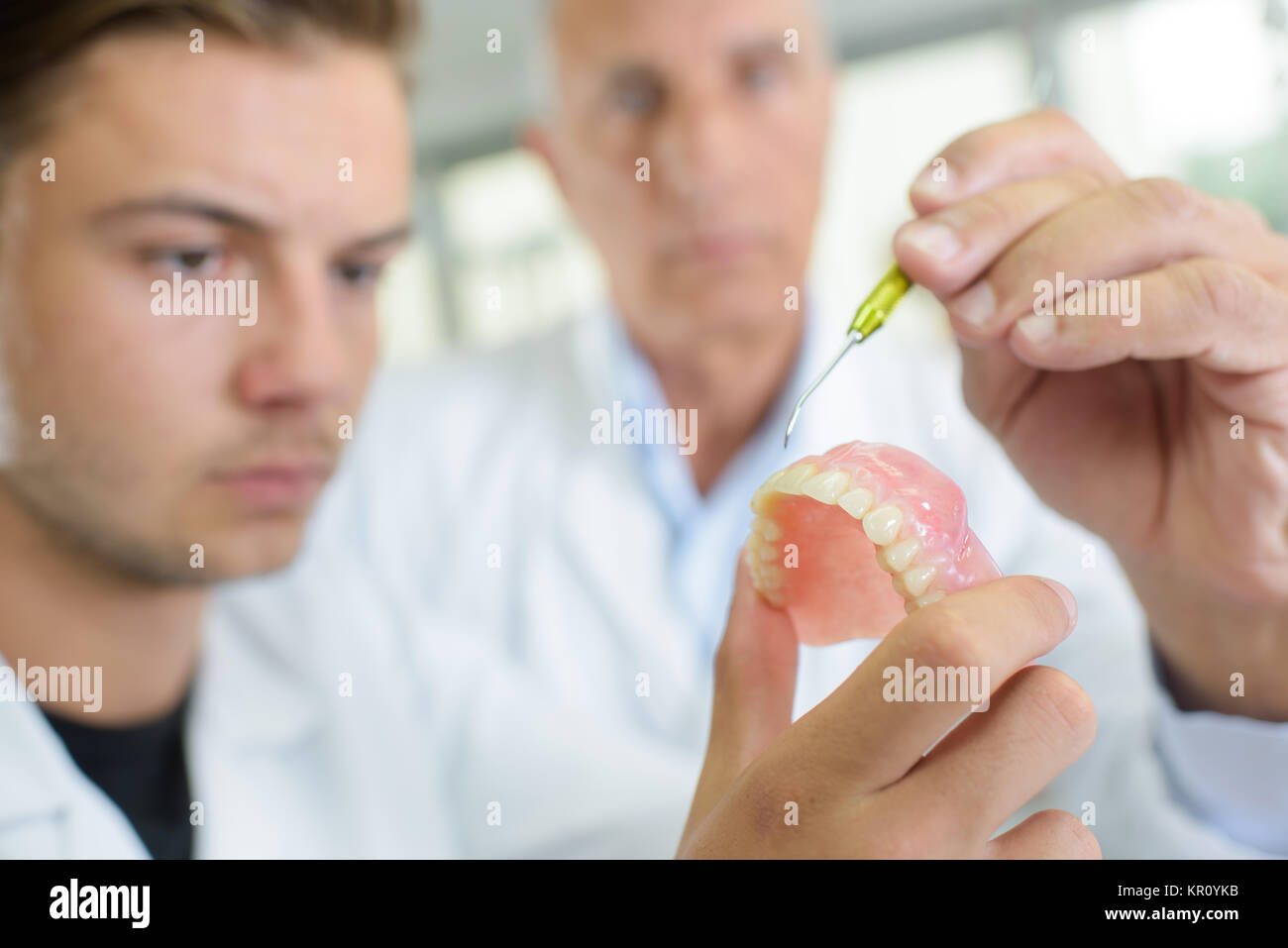 Male technician working on dentures with sharp tool Stock Photo - Alamy