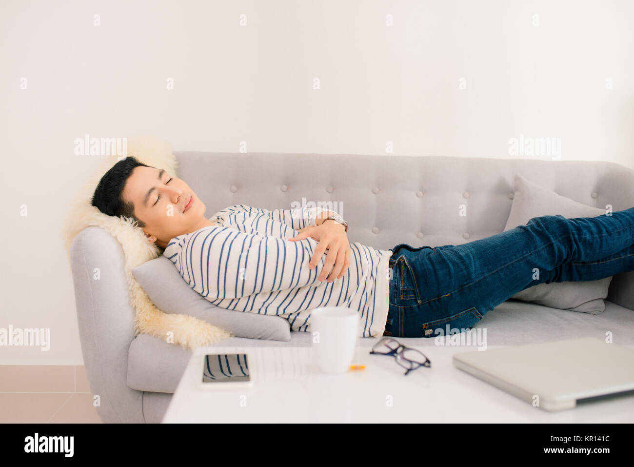 Young handsome boy sleeping on sofa in living room at home Stock Photo ...
