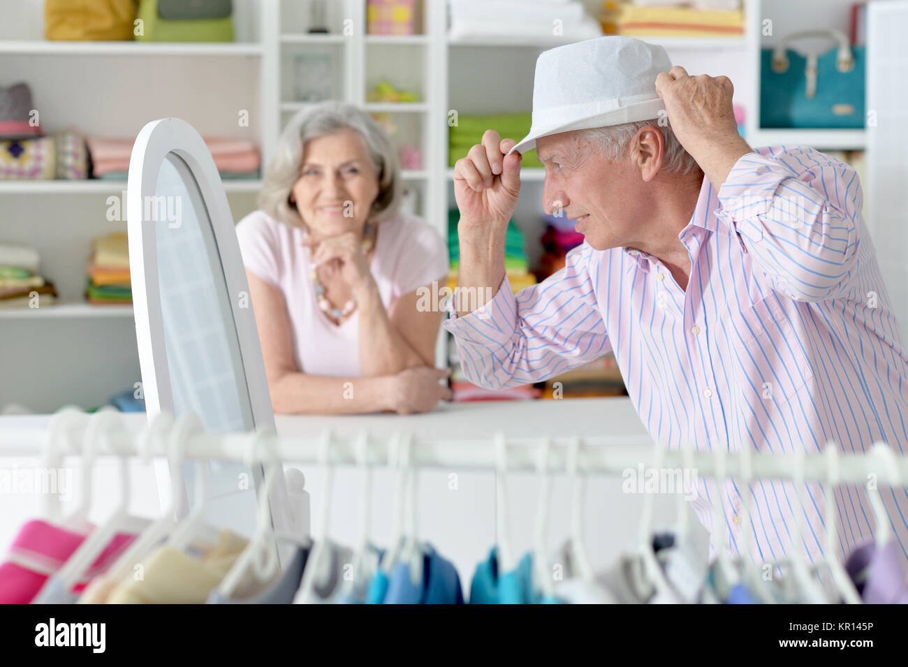 Senior couple choosing hat Stock Photo - Alamy