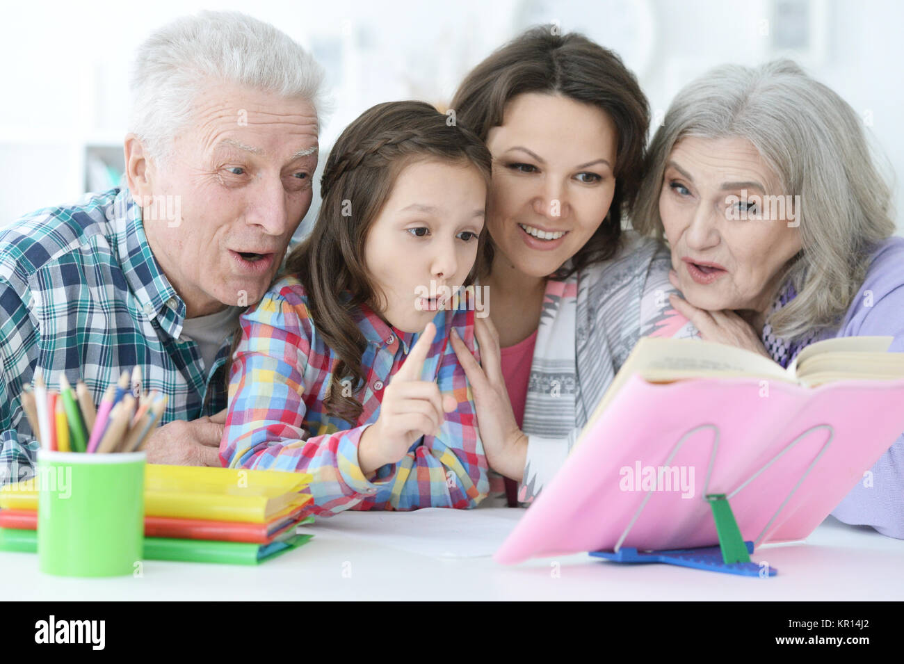Big family with cute little girl doing homework Stock Photo - Alamy