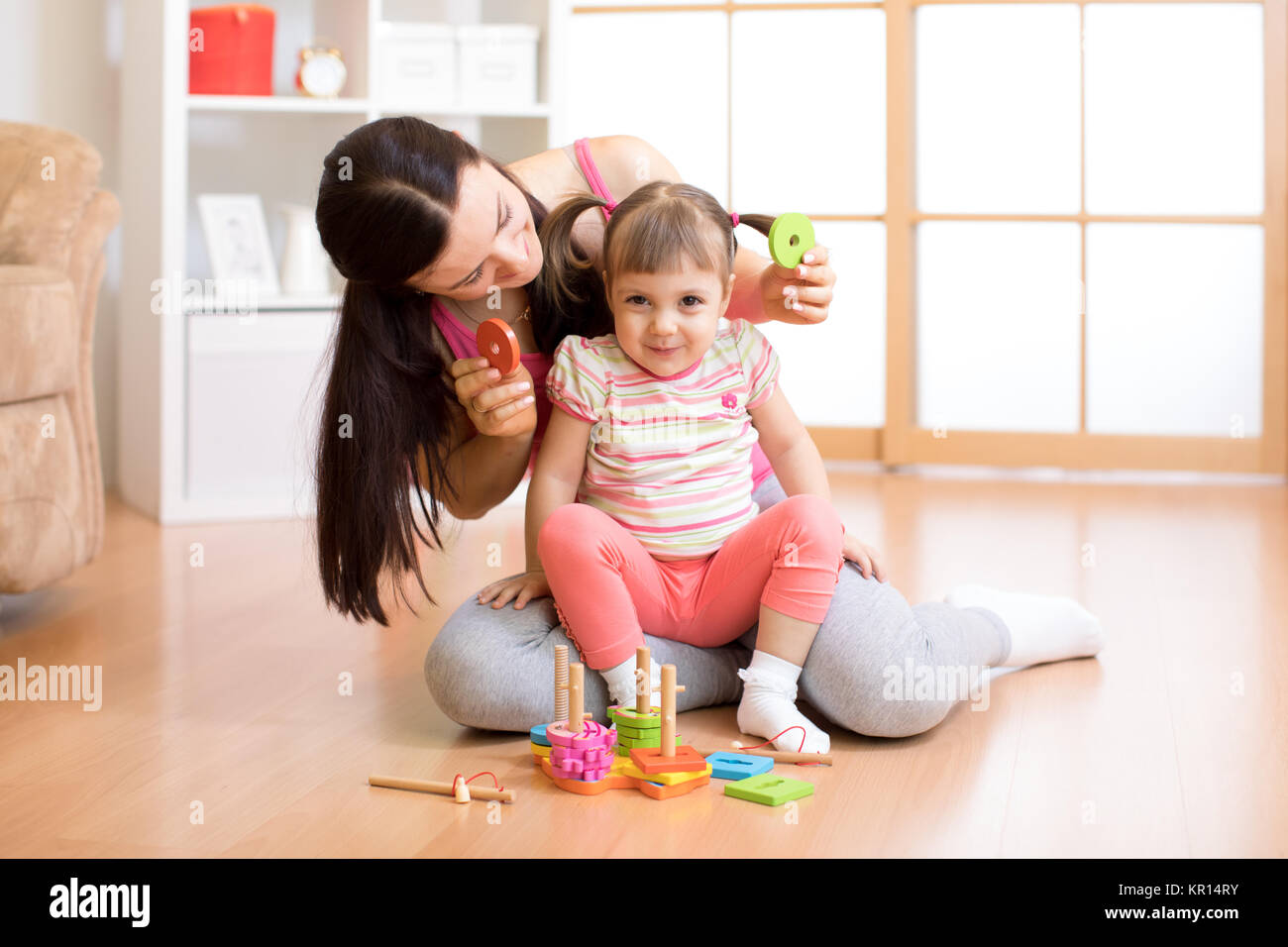 kid and mother play together with puzzle toy Stock Photo - Alamy