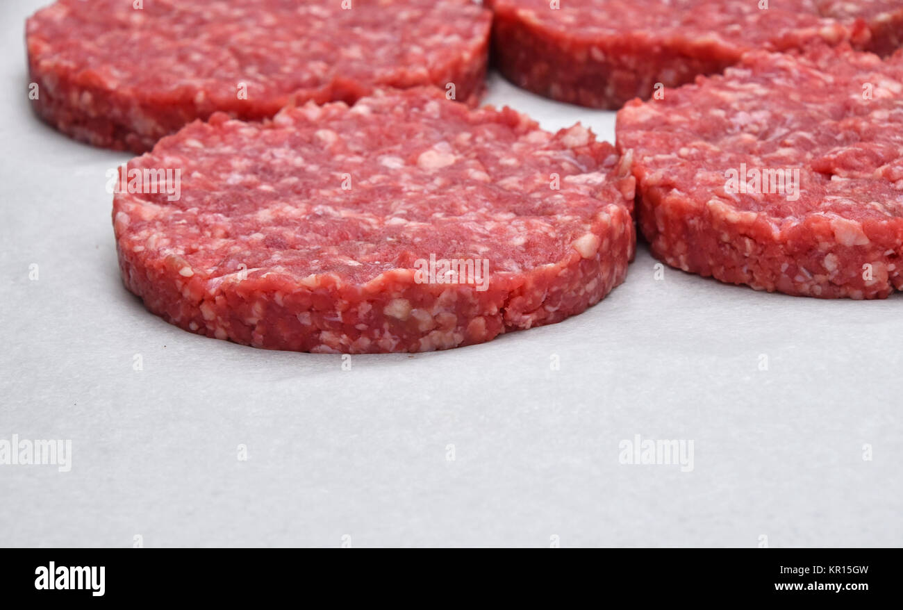 Raw meat burgers for hamburgers on parchment Stock Photo - Alamy