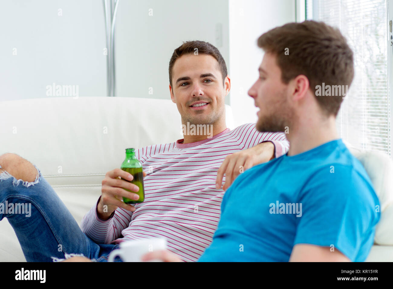 Two Men Drinking Beer At Home Stock Photo - Alamy