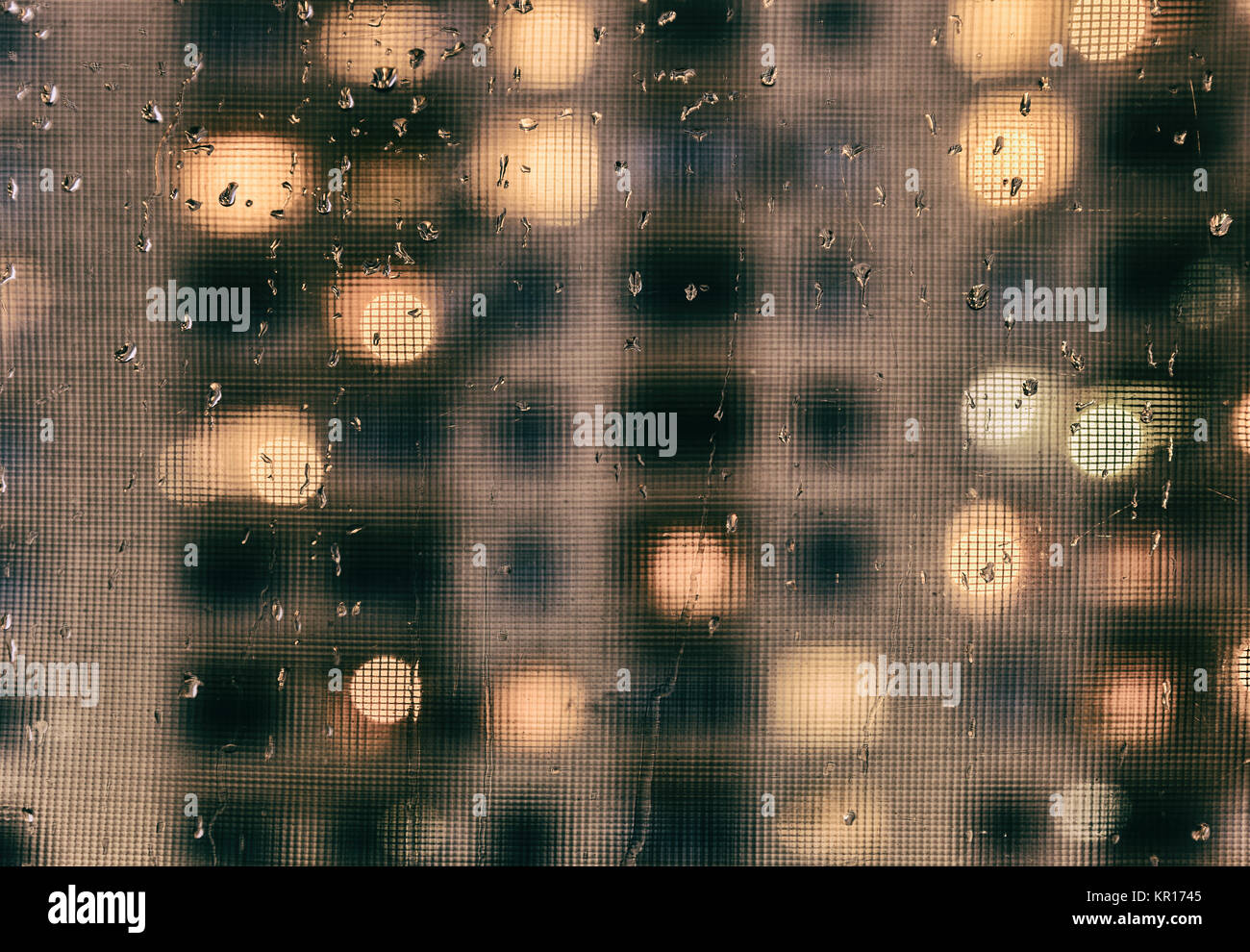 Glass covered with rain, through which you can see the windows of the ...